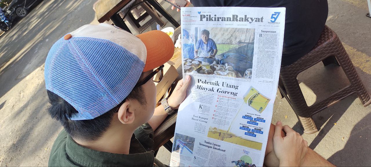 Pembaca Berita Media Cetak di Bandung Sedang Membaca Berita - Berita Daerah